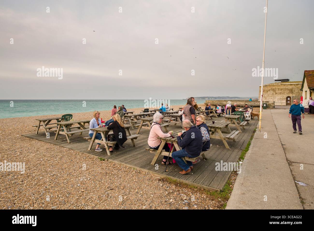 People sitting on picnic benches with Martello Tower number 74 in ...