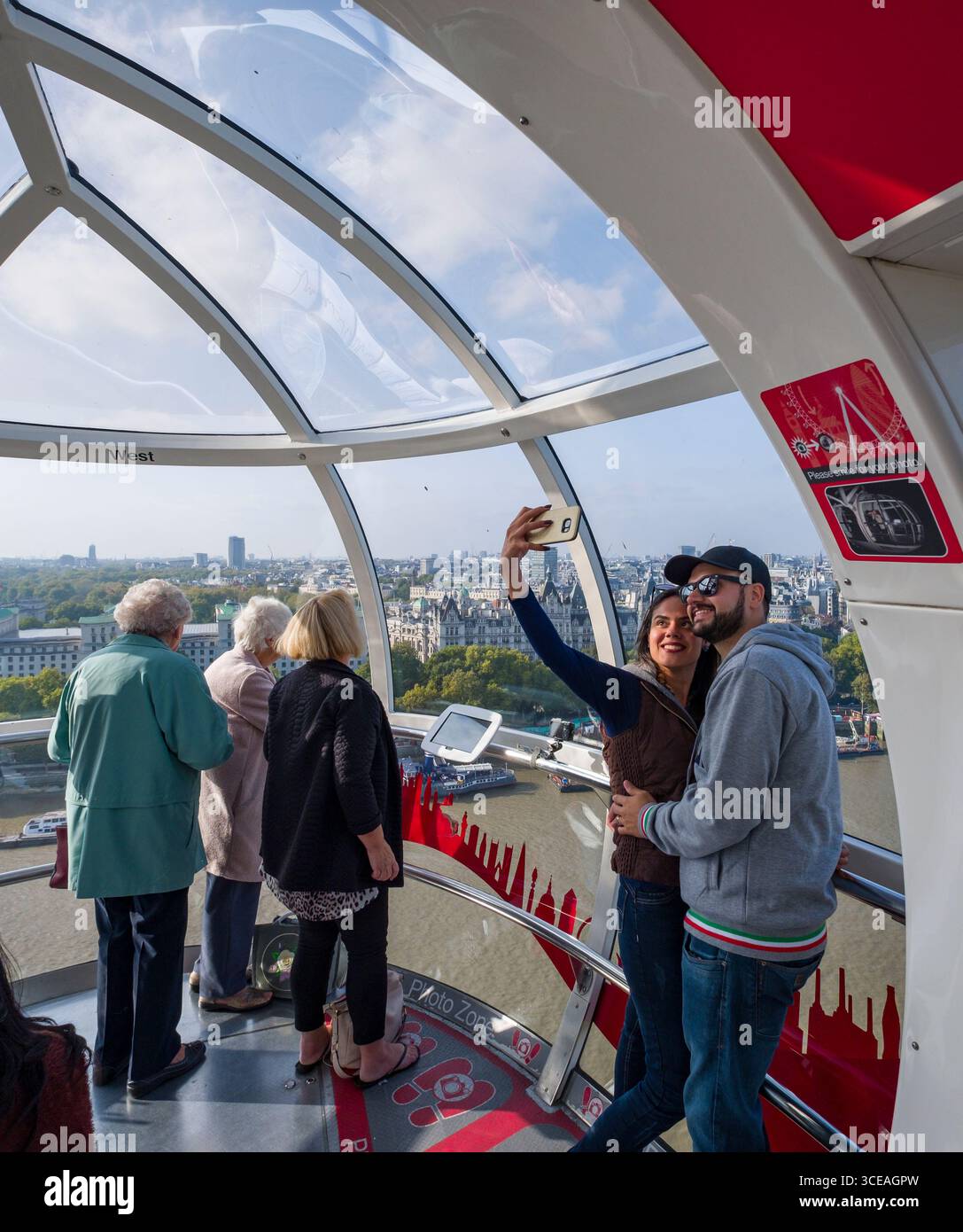 Woman holding smartphone for a selfie inside passenger capsules of the ...