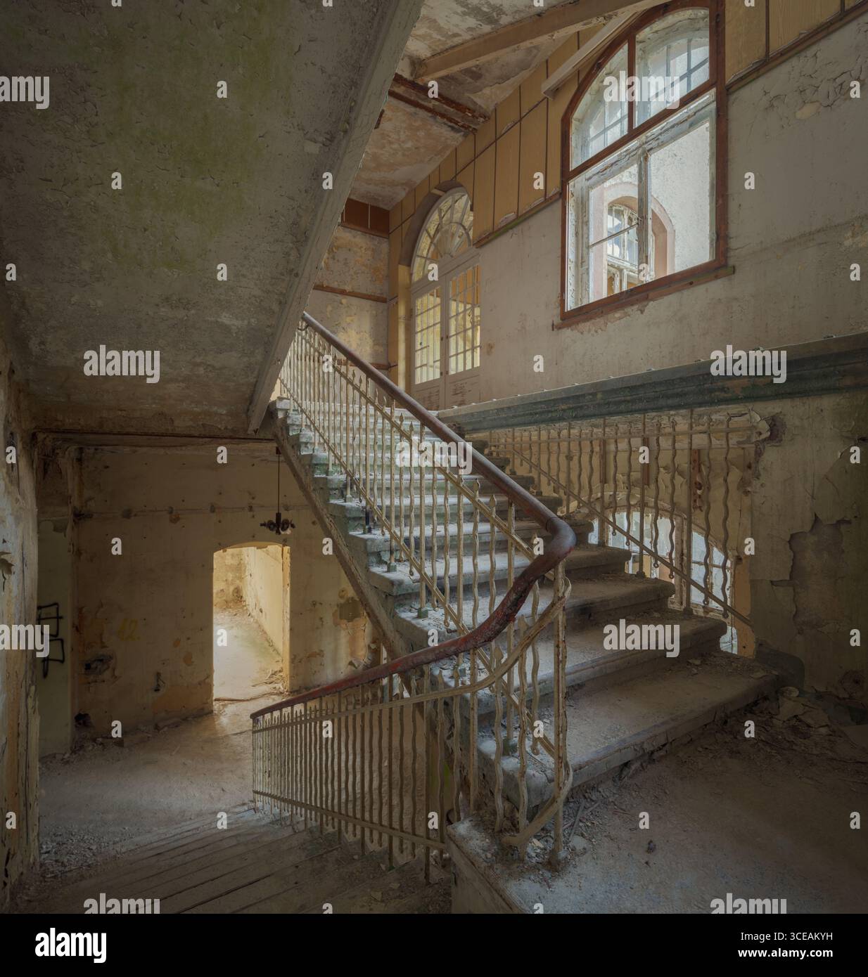 Abandoned historic building interior with stone archway, staircase and ...