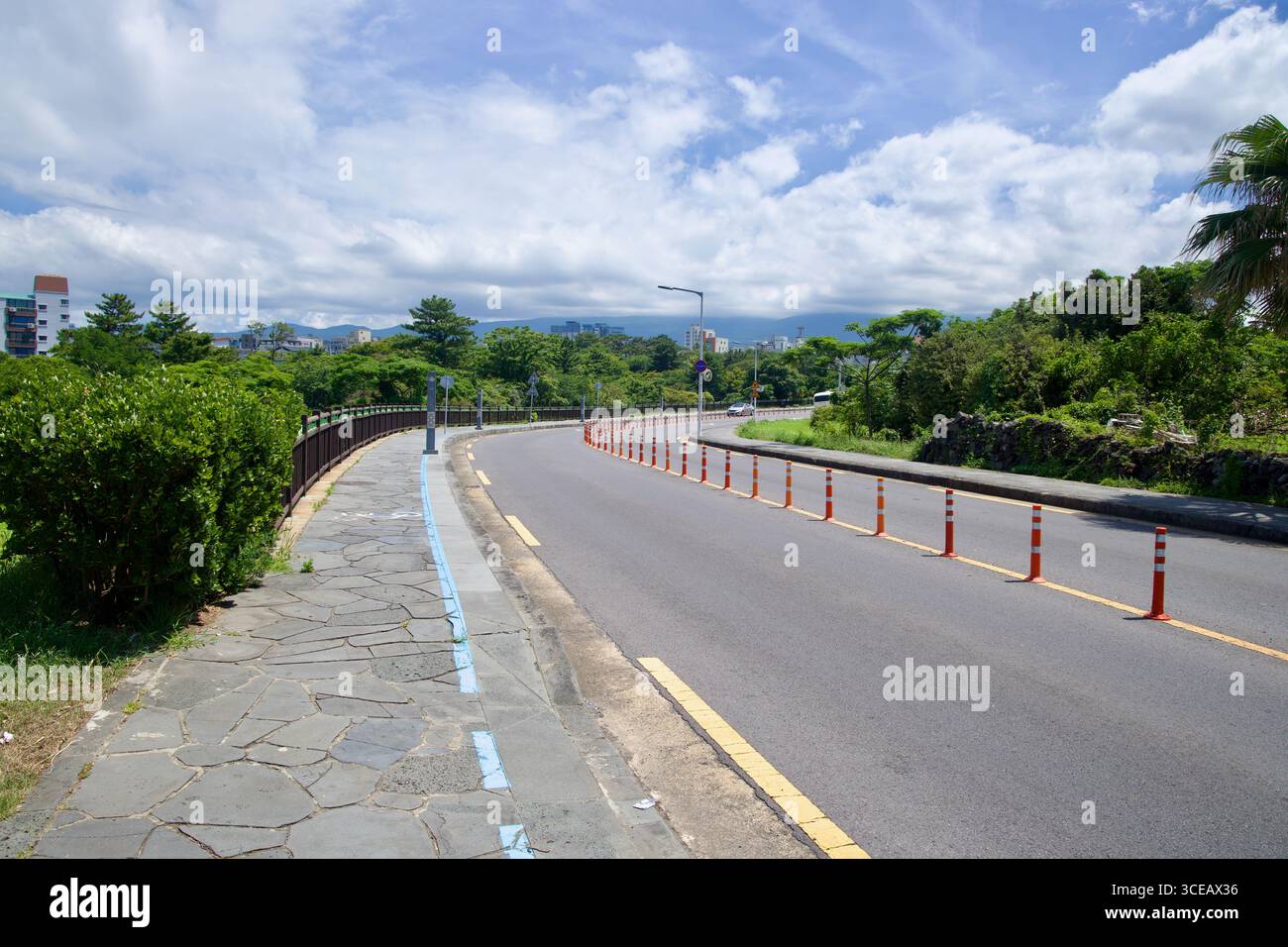 A curved approach road near Yongyeon Valley in Jeju City shows a stone ...