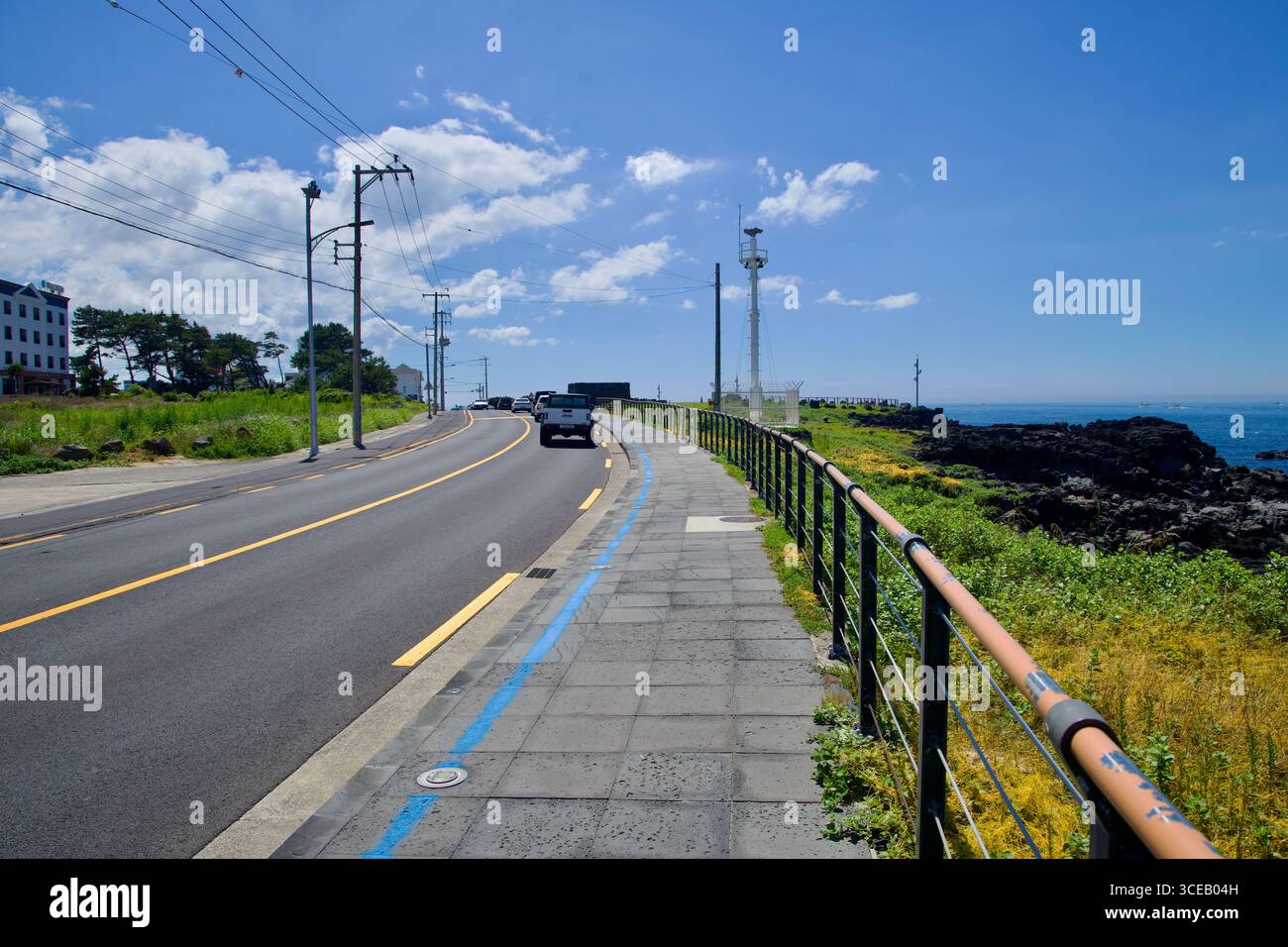The Hagu‑Aewol Coastal Road curves above a basalt shoreline beside ...
