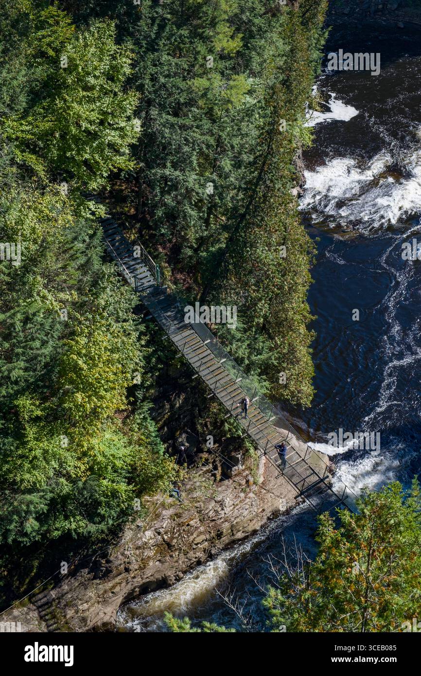 People on suspension bridge crossing the Sainte-Anne-du-Nord River ...