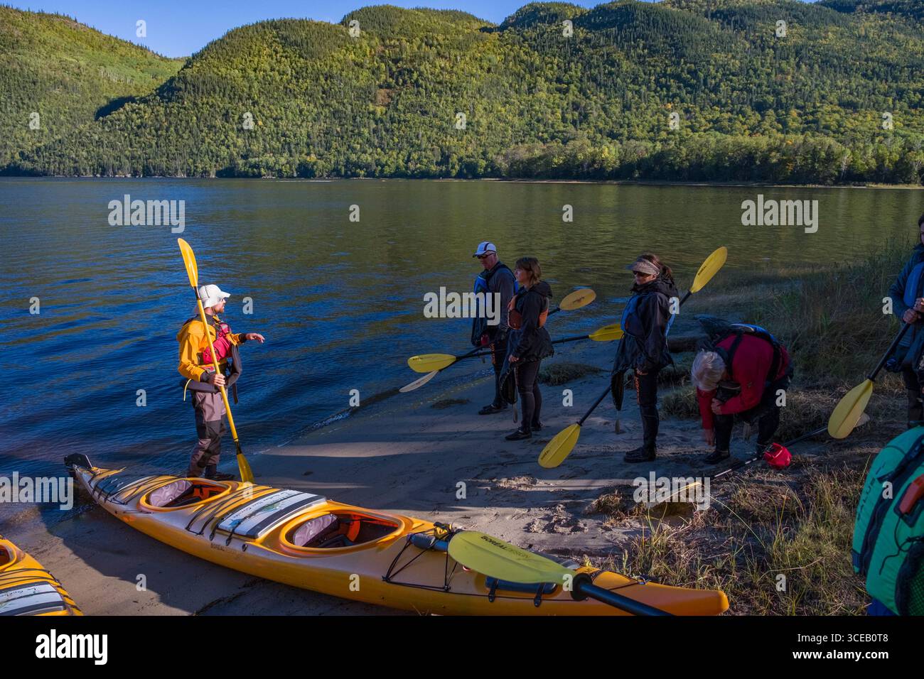 Male kayak guide giving instruction to a group of tourist before a ...