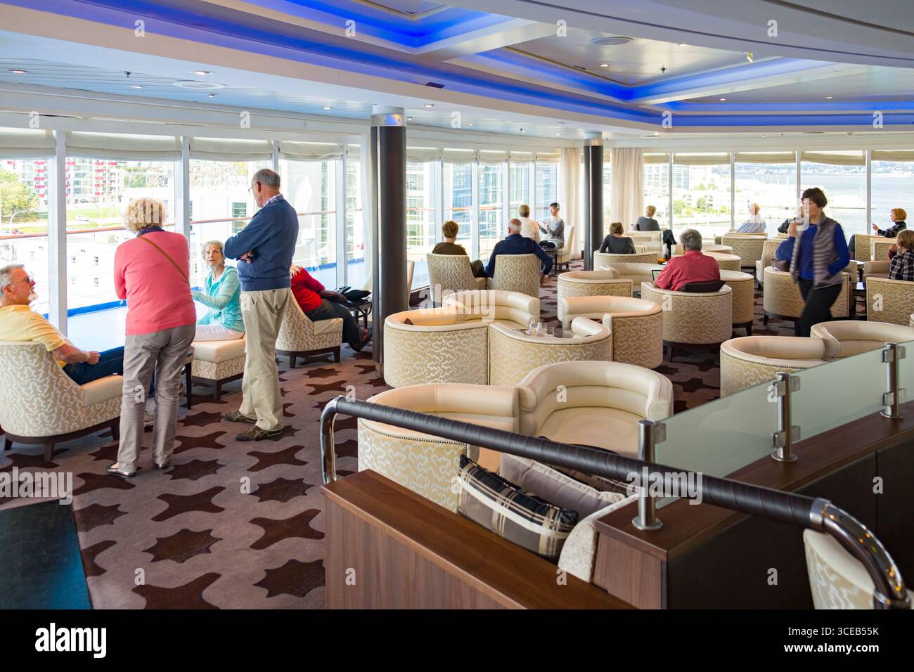 Passengers relaxing in the observation lounge aboard the Regent Seven ...