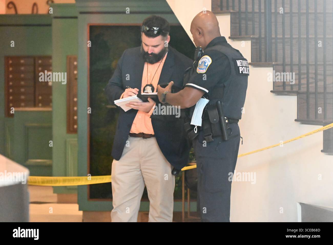 Police officers, EMS workers and detectives work at the scene where ...