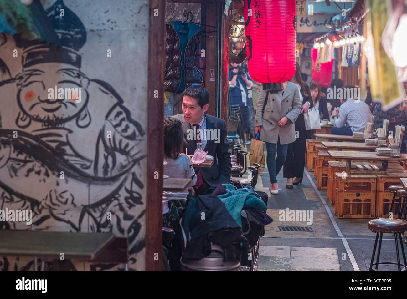 People sitting at tables eating and drinking inside Ebisu Yokocho an ...