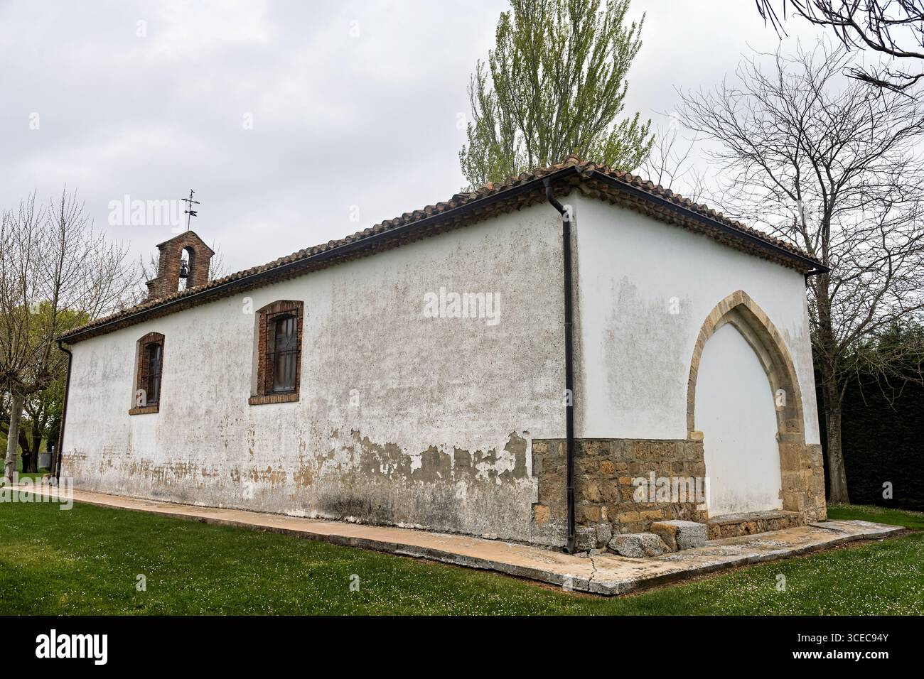 Small red brick chapel with arched stone doorway and bell tower in ...
