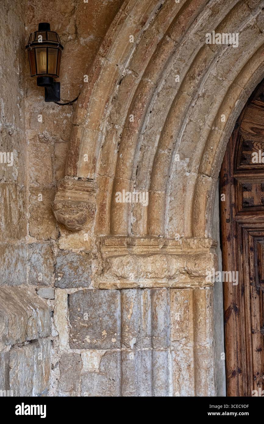 Pointed stone arch framing a carved wooden church door in Itero de la ...