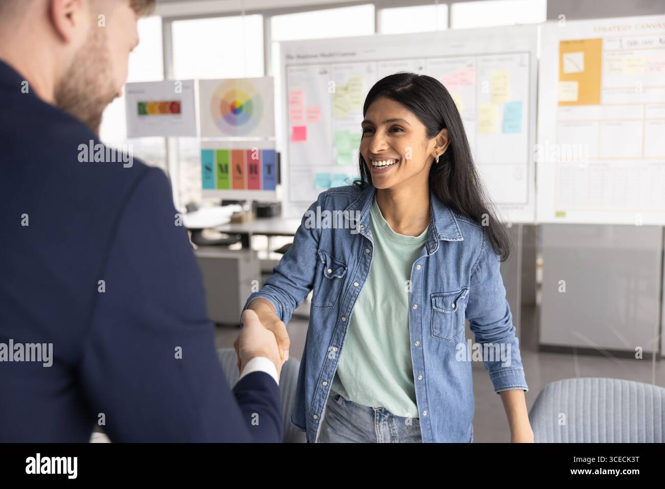 Happy startup owner woman giving handshake to businessman Stock Photo ...
