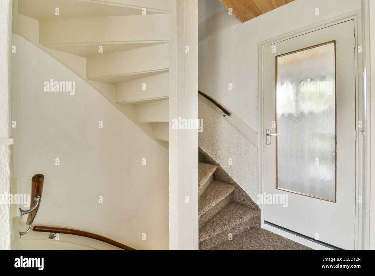 A modern interior featuring a staircase with a clean design and a door ...