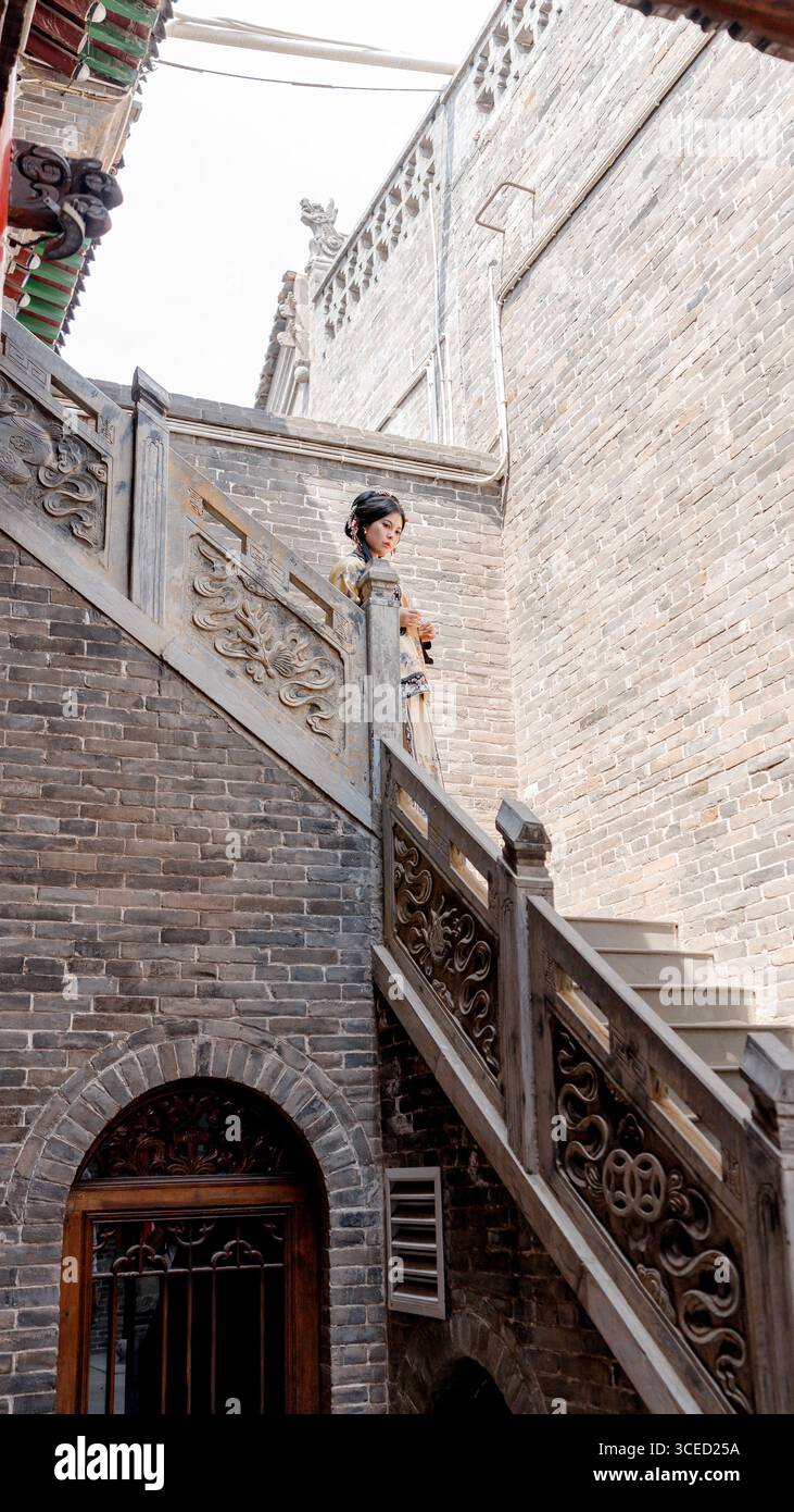 A woman wearing traditional Qing Dynasty attire stands gracefully on an ...