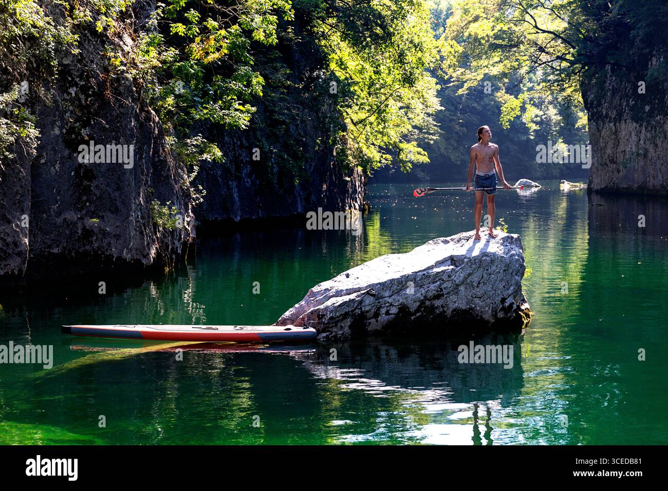 Tourist on standup paddle board on a trip paddling, exploring beautiful ...