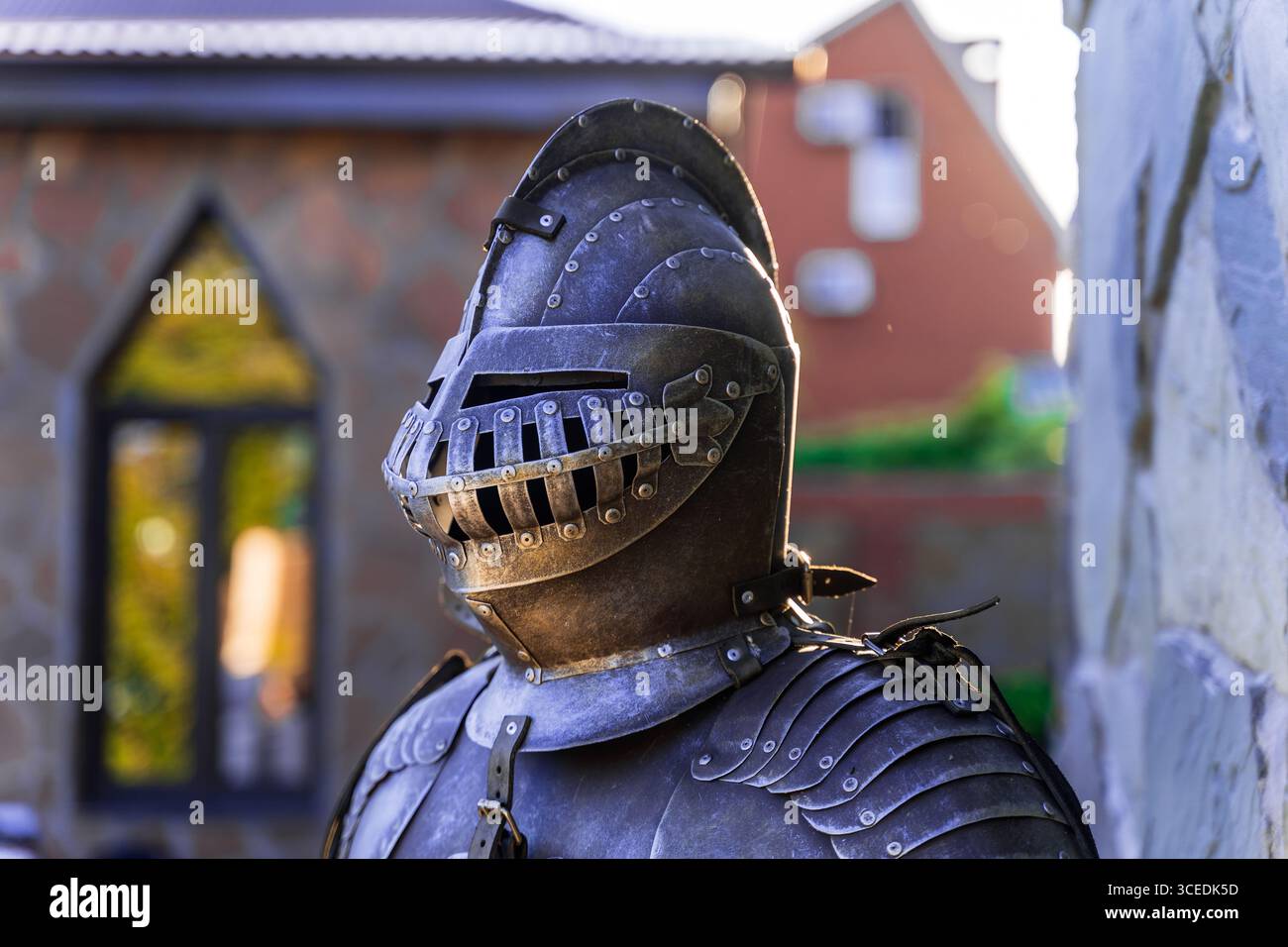 A knight in full armor holding a sword. The knight is wearing a red and ...