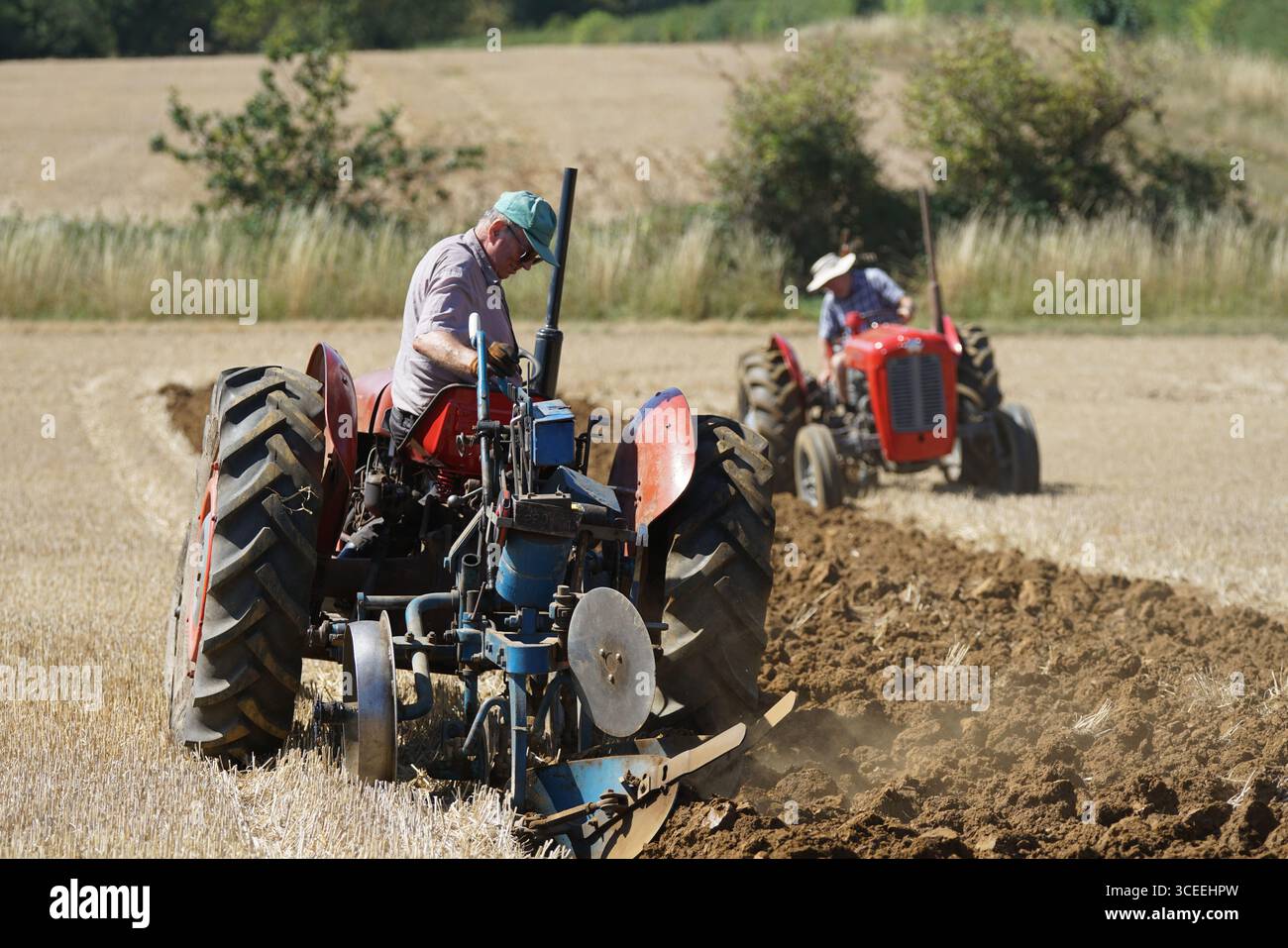 Two Farmers Operating Vintage Tractors in Rural Field During ...