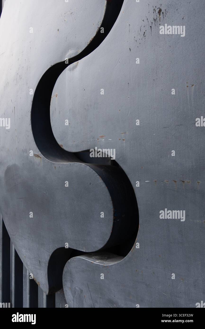 wavy metal cut out of a silver chrome metal wall s shaped shadow in ...