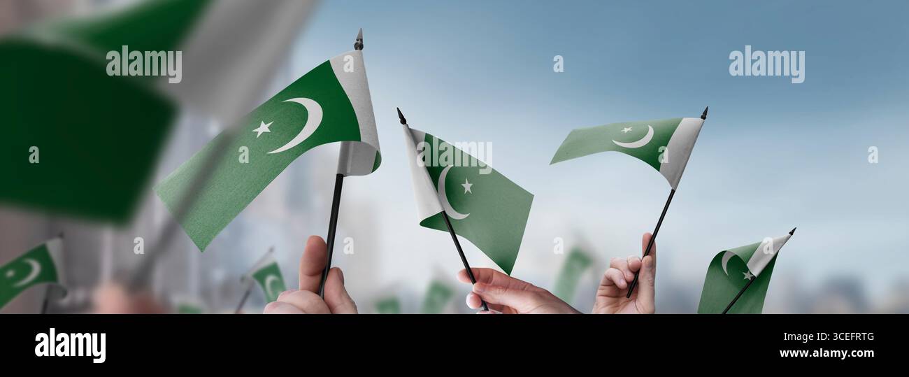 Pakistan flags in their hands on a blurred urban background Stock Photo ...