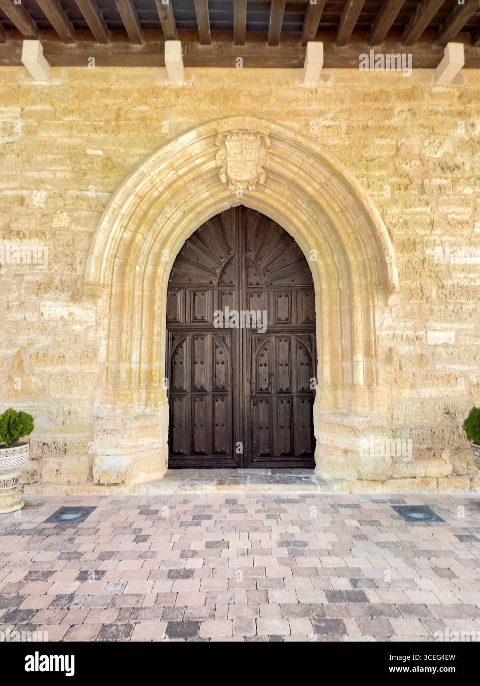 Gothic stone arch with carved coat of arms and wooden double door in ...