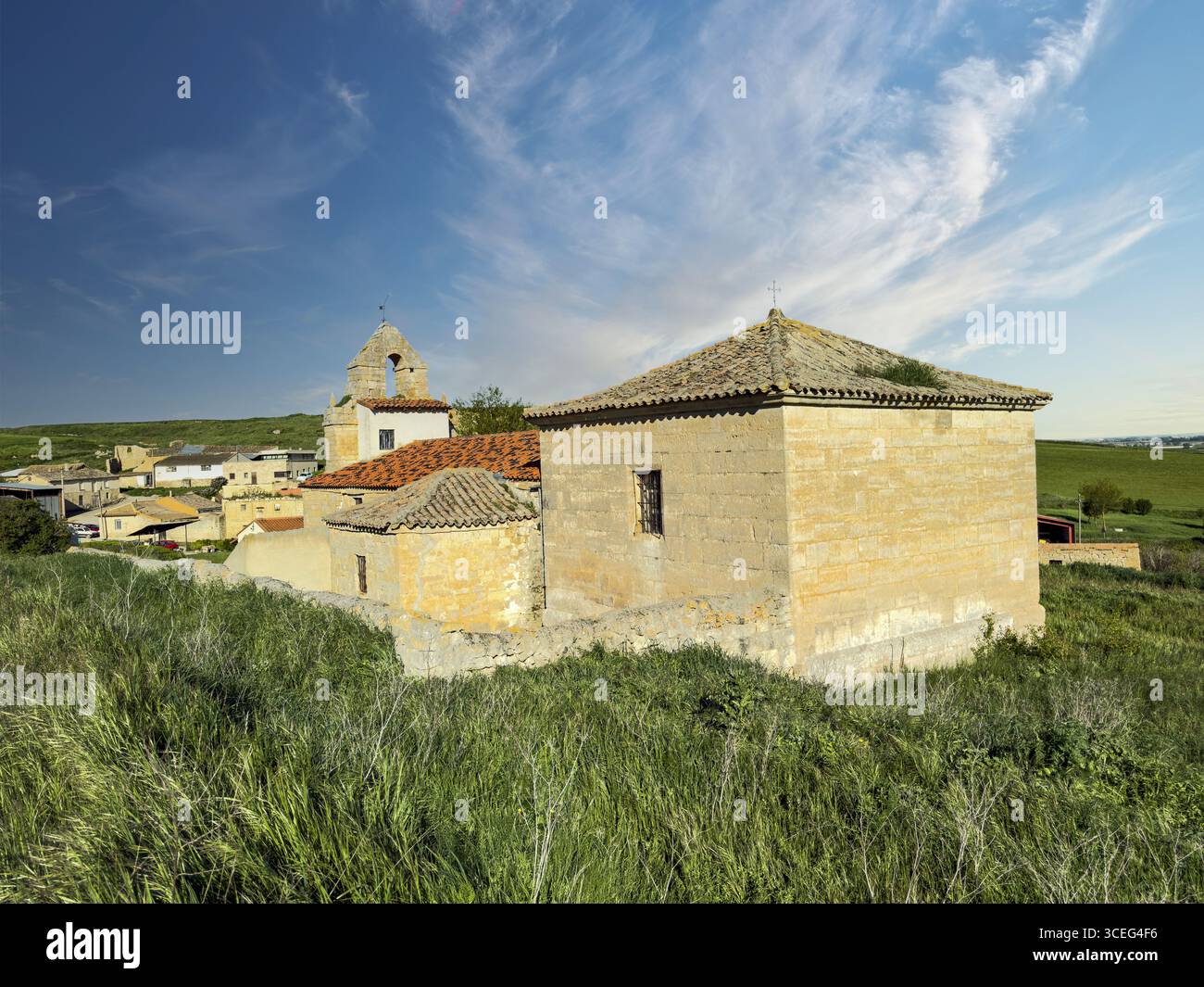 Rural church with stone walls, tiled roofs and bell gable surrounded by ...