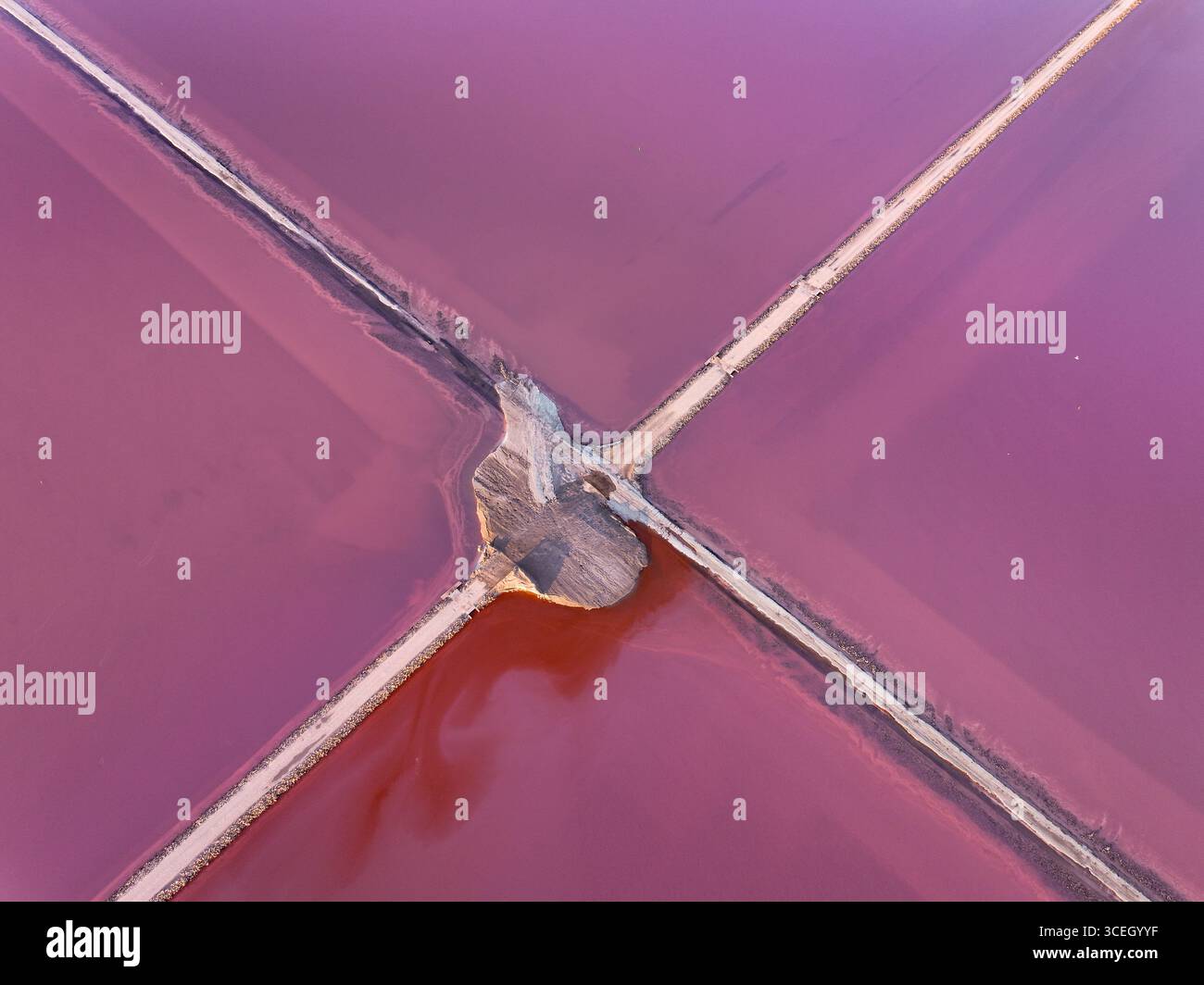 Aerial view of vibrant pink salt marshes divided by stark white ...