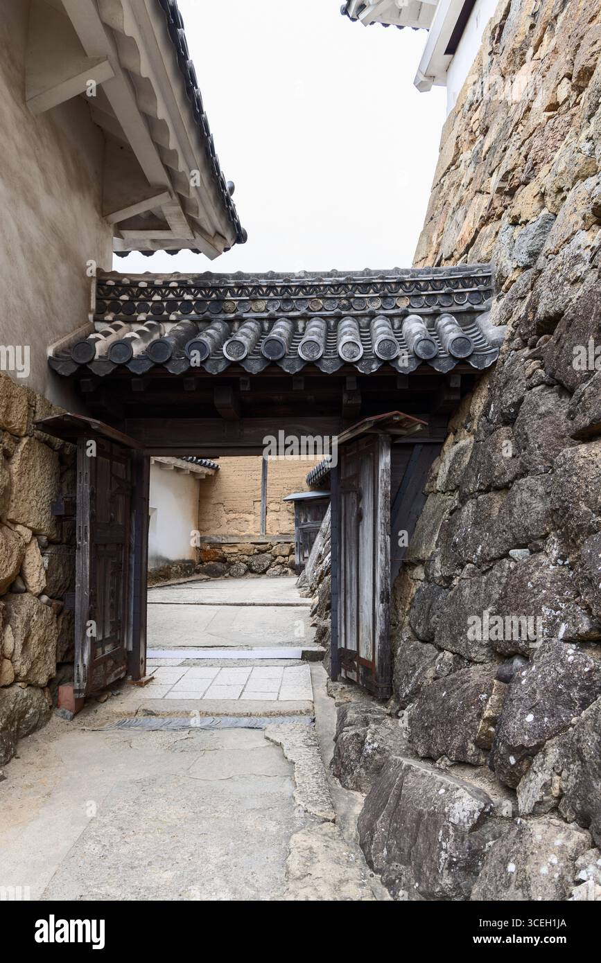 Passageway with wooden gate and kawara tiled roof in Himeji Castle ...