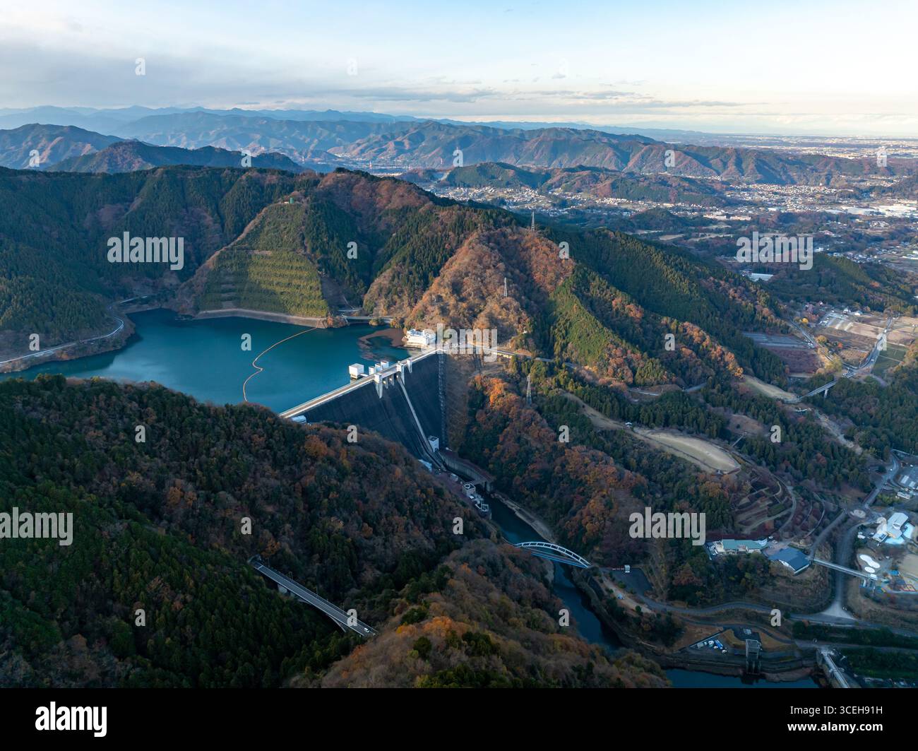 Aerial view of the Miyagase Dam nestled amid forested mountains ...