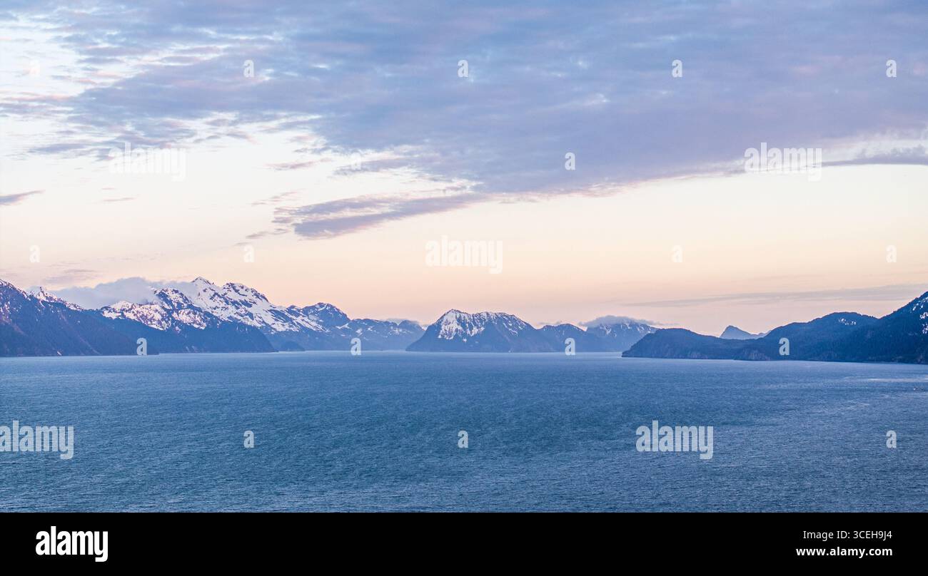 Aerial view of the ocean's expanse meets the snow-capped mountains ...