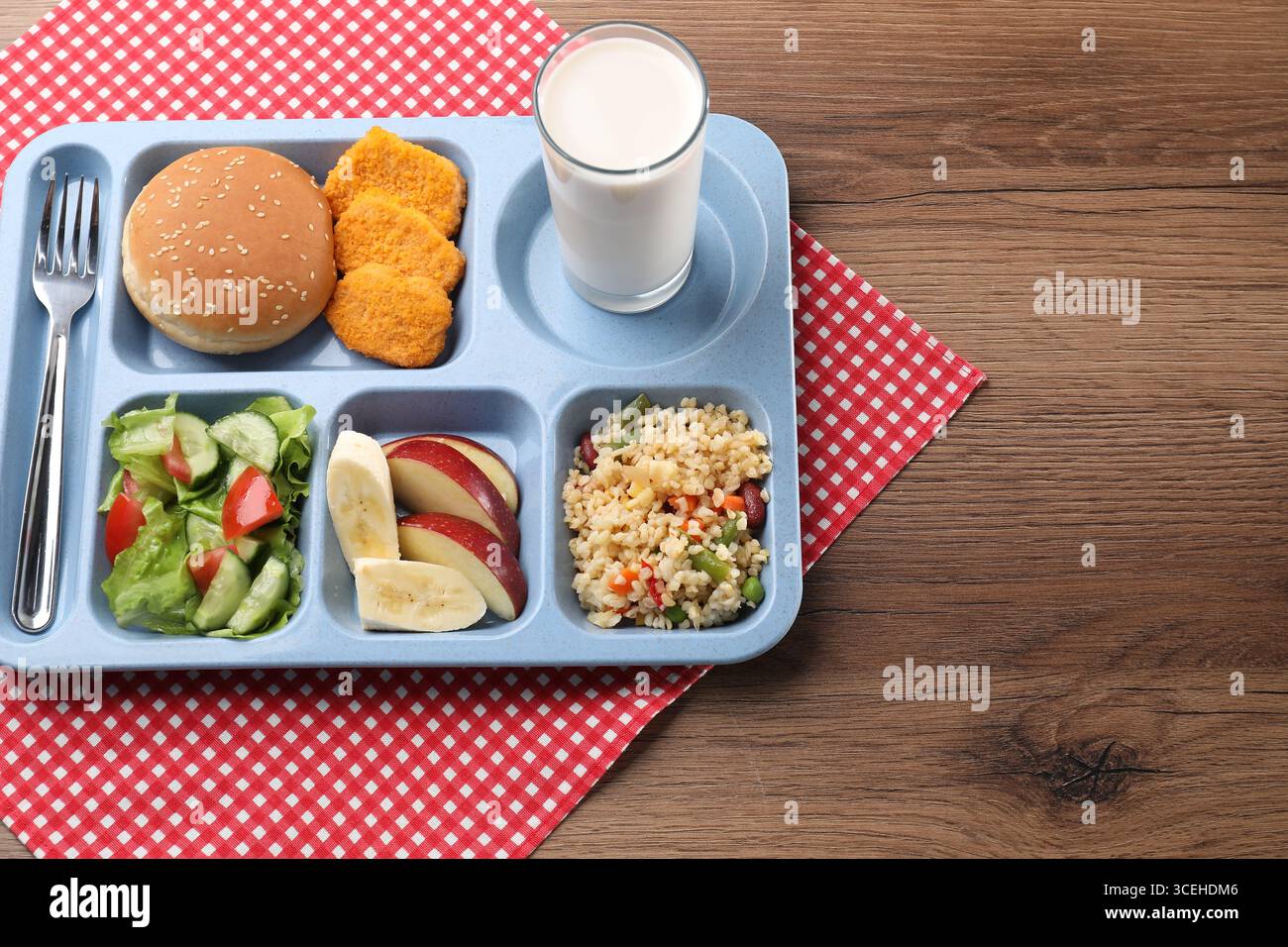 School lunch. Plastic tray with tasty food, milk and fork on wooden ...