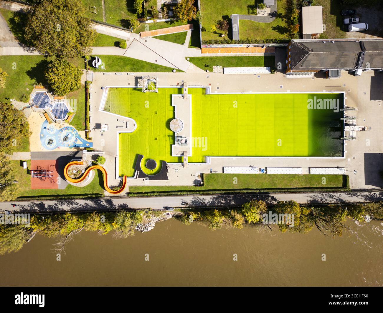 Aerial view of the vibrant green water of the swimming pool contrasting ...