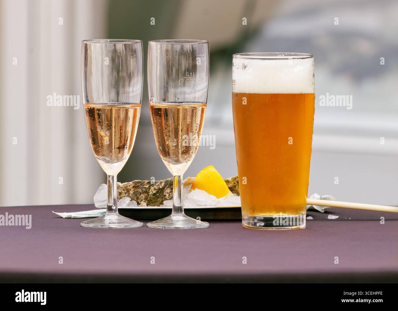 Close-up of two champagne glasses and a pint of beer placed on a table ...