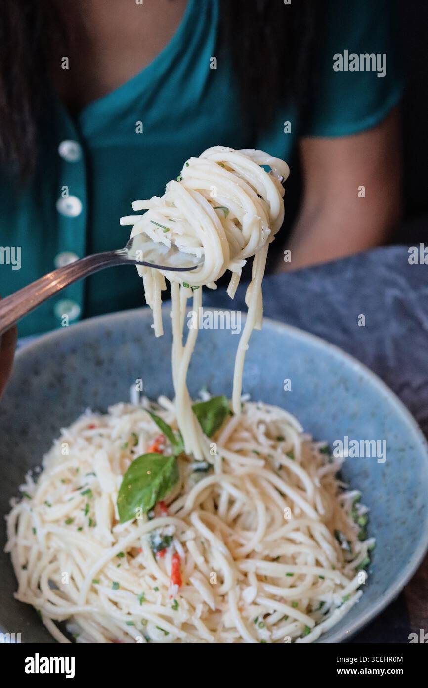 fork twirling creamy spaghetti pasta with herbs, parmesan, and basil ...