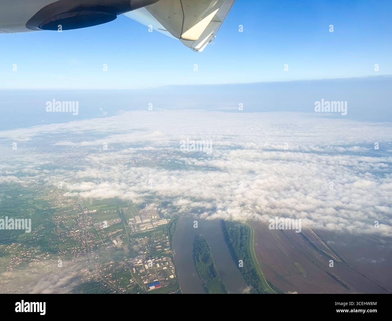 Aerial view of clouds over city and river from plane. Altitude ...