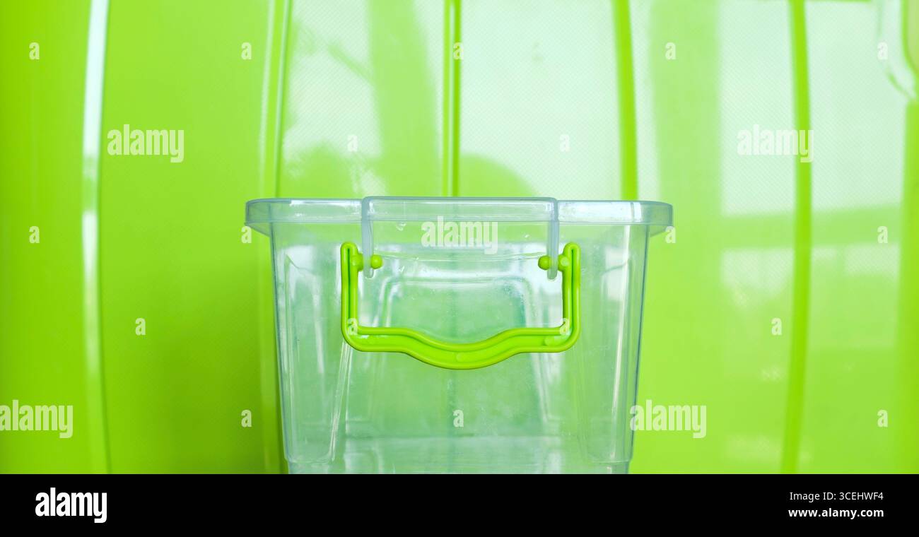 Empty transparent plastic storage container with green handle and lid ...