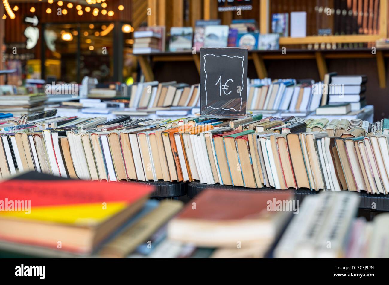 Old books arranged on table at flea market with visible price tag of 1 ...