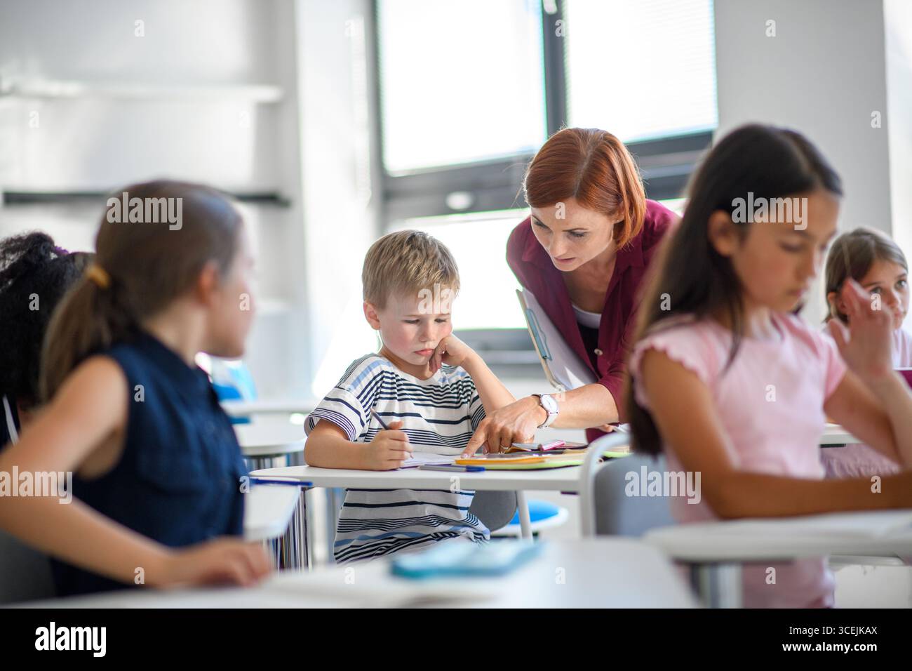 Teacher talking with children in primary class Stock Photo - Alamy