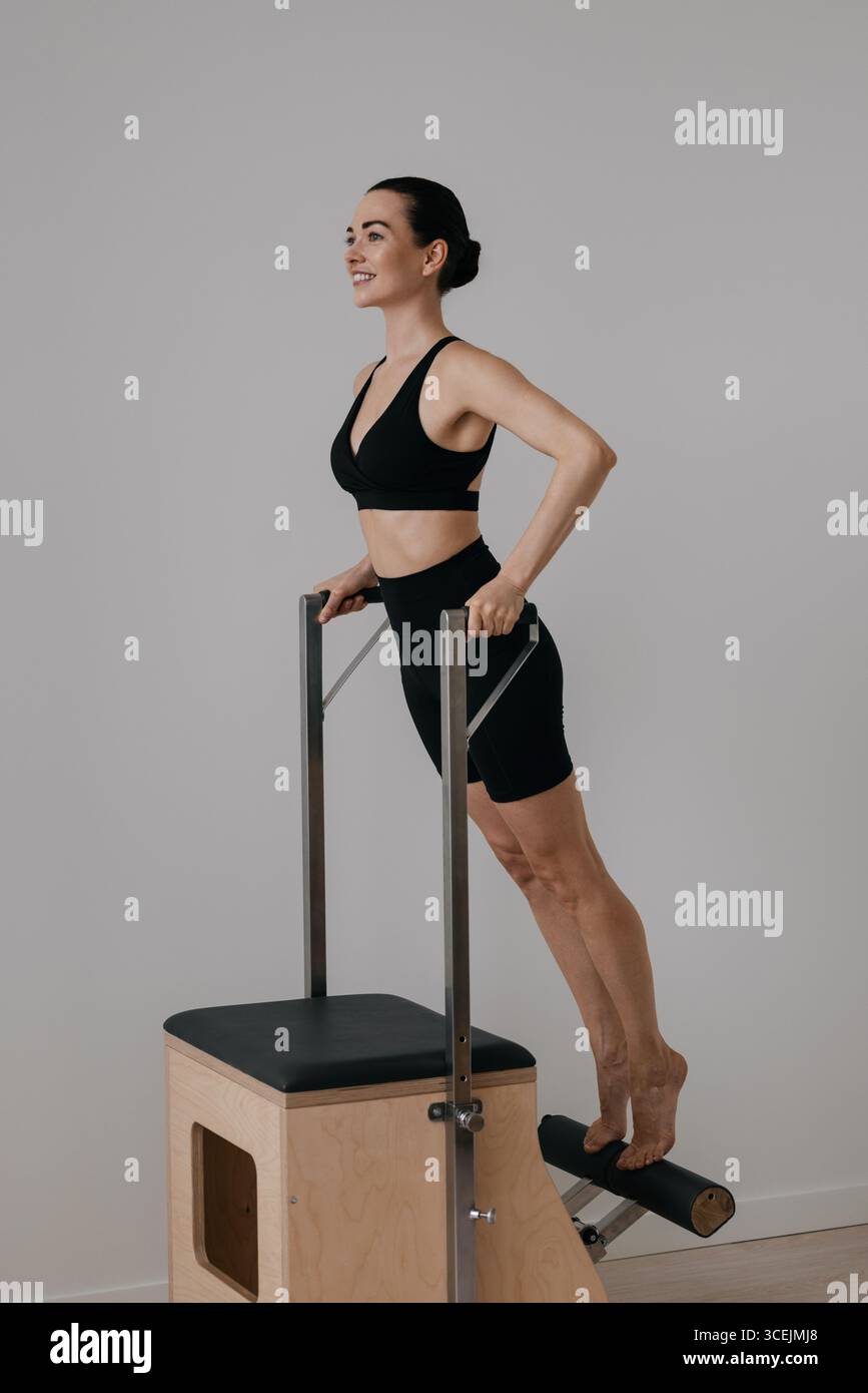 Pilates reformer chair with natural wood details used for training ...