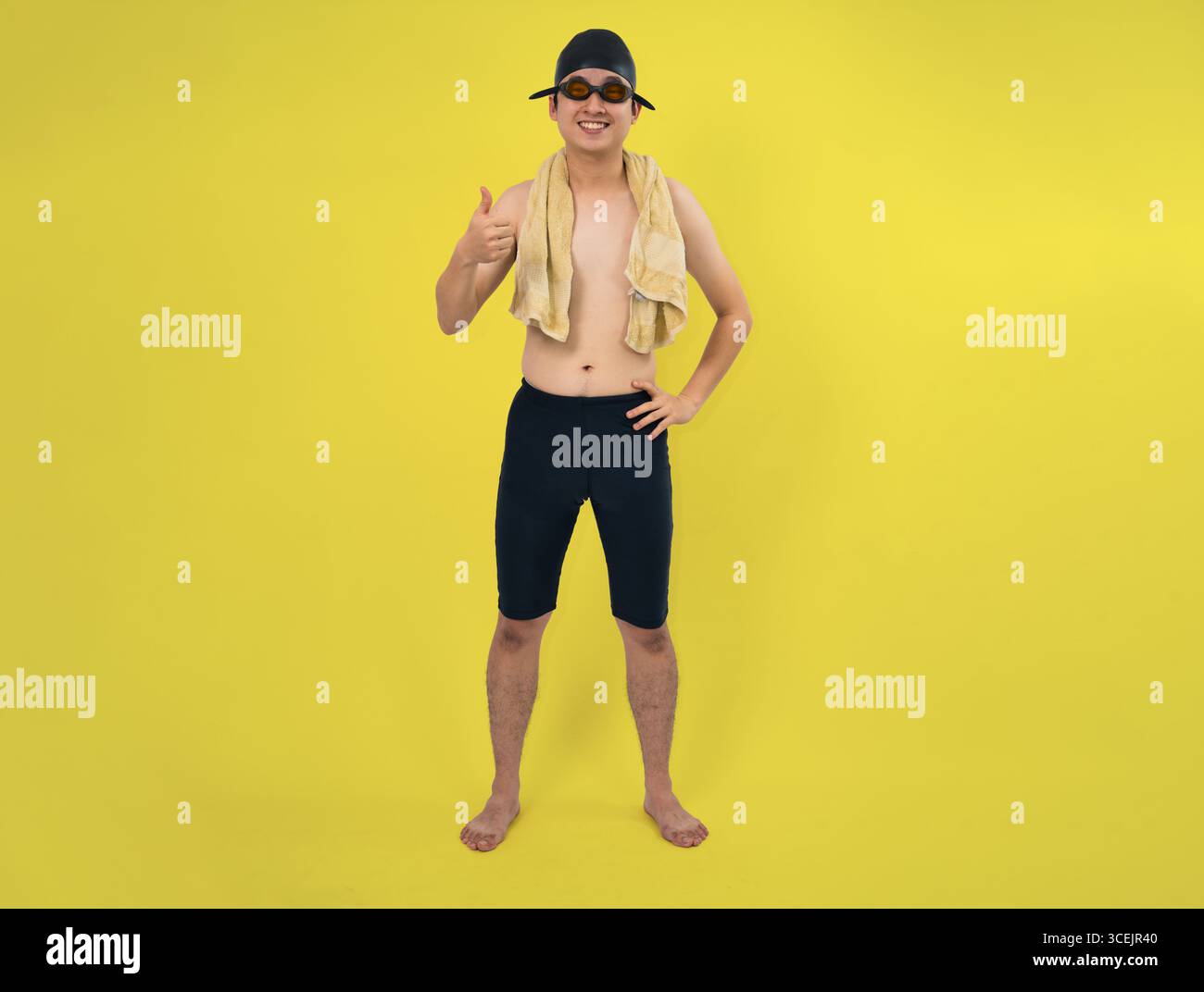 confident male swimmer in sports outfit against yellow background ...