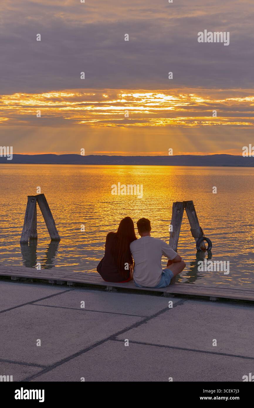 Romantic couple sits on pier hi-res stock photography and images - Alamy