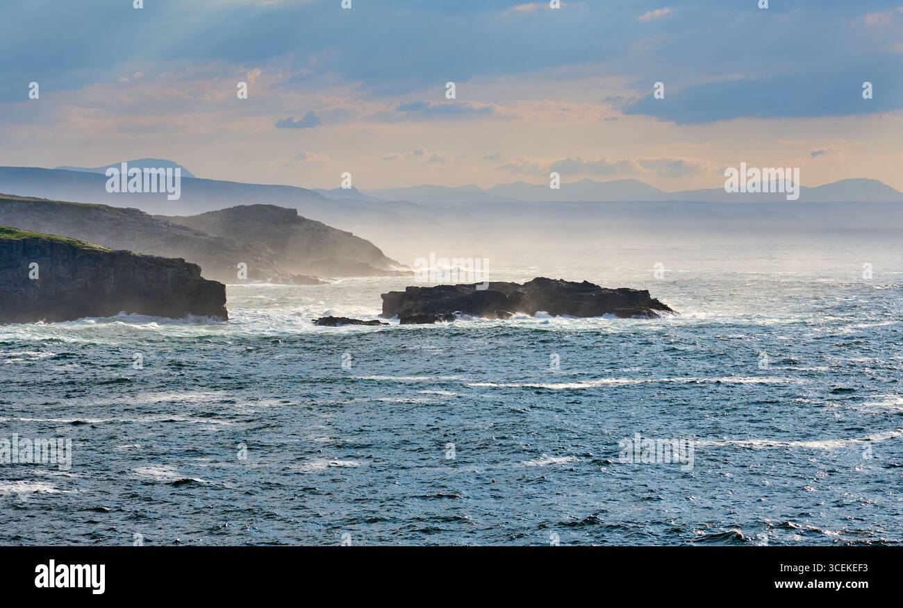 rocky cliffs and rough sea with lighthouse at Strathy Pont in Northern ...