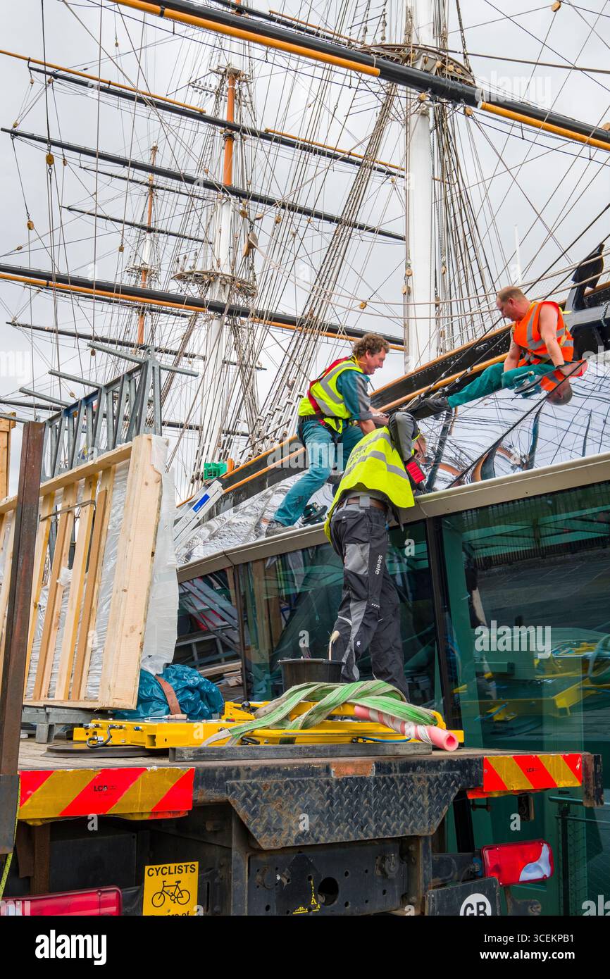 Men working on glass panel at the Cutty Sark British clipper ship ...