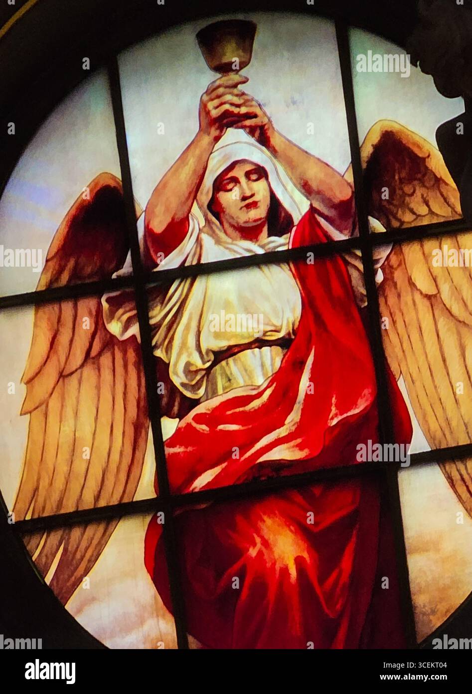 A detailed view of a circular stained glass window depicting an angel ...