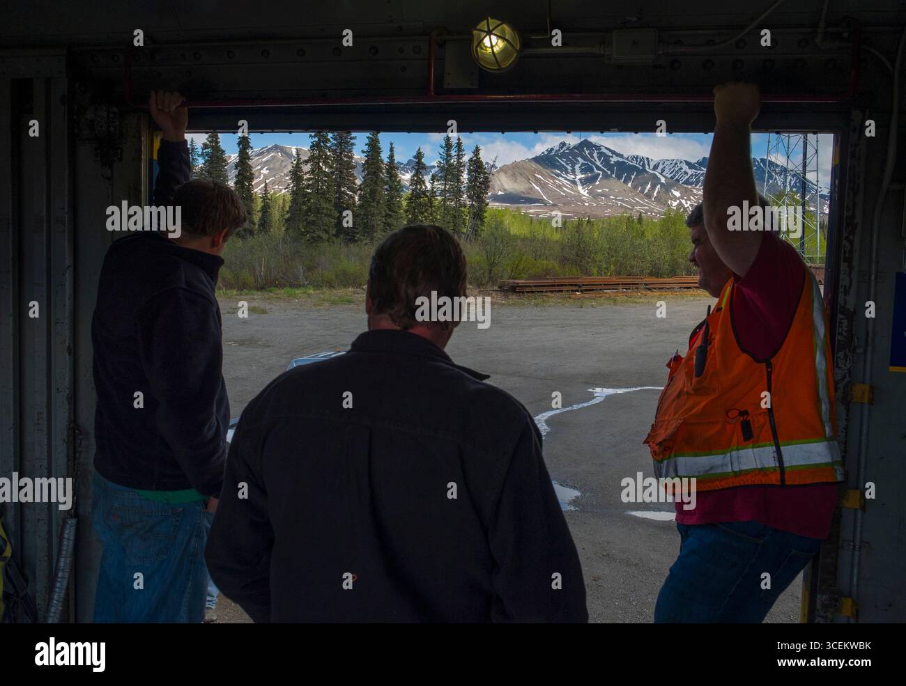 Men standing in doorway of the baggage car aboard the Alaska Railroad ...