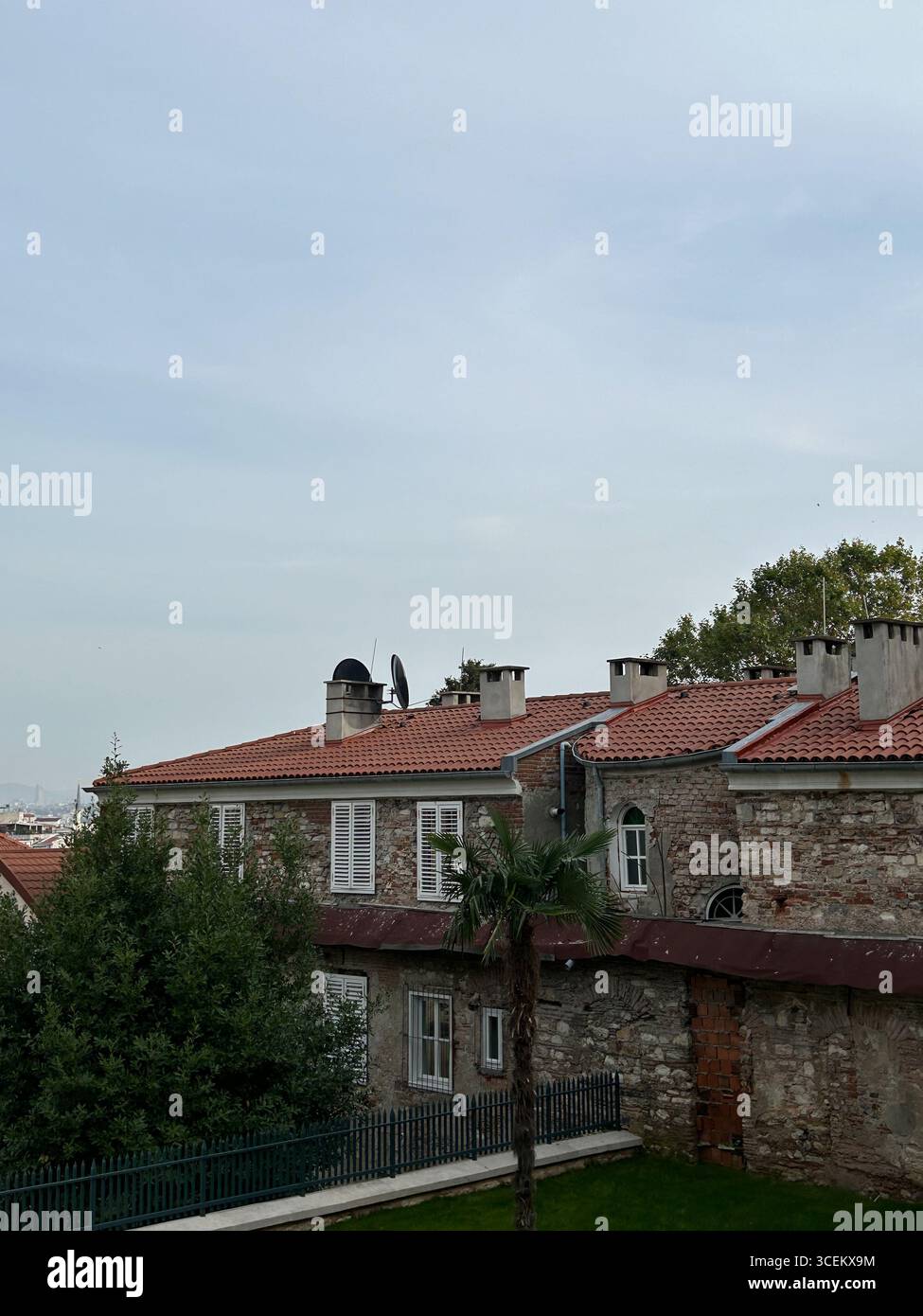 The photo shows a row of connected stone residential buildings with red ...