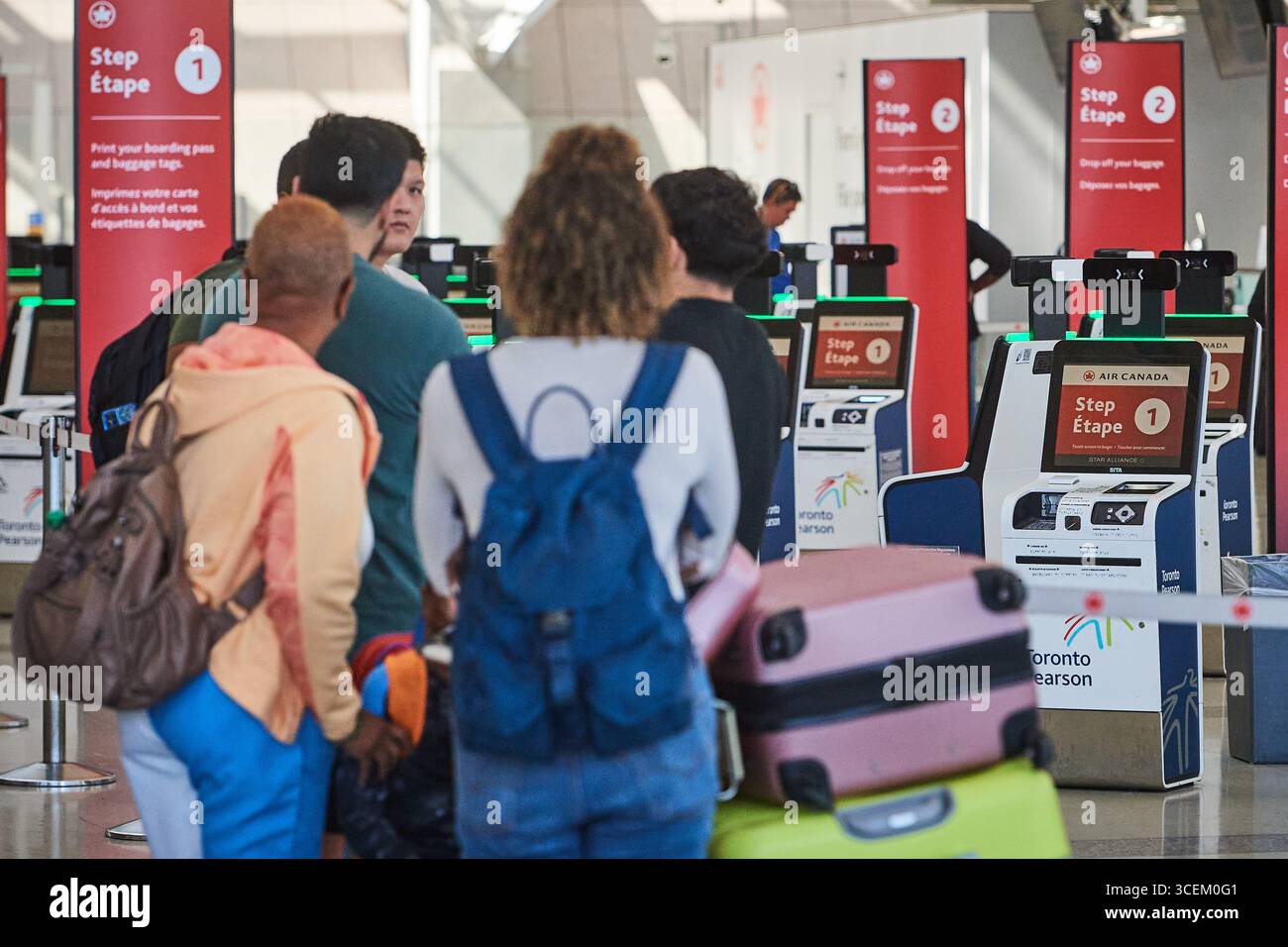 Travellers pass by the Air Canada departure gates as flight attendants ...