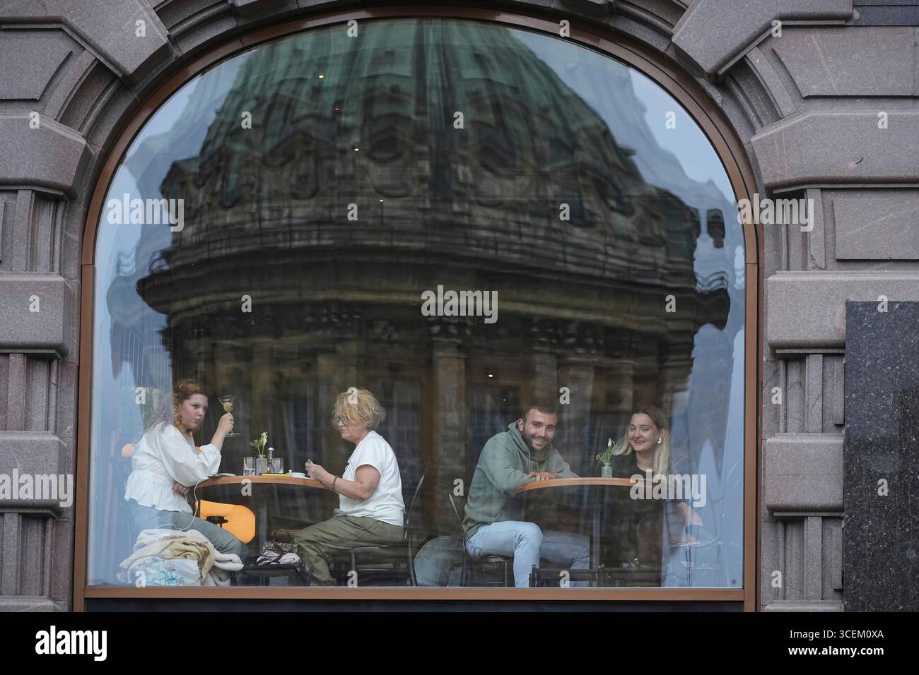 People sit in a cafe in St. Petersburg, Russia, Monday, Aug. 18, 2025 ...