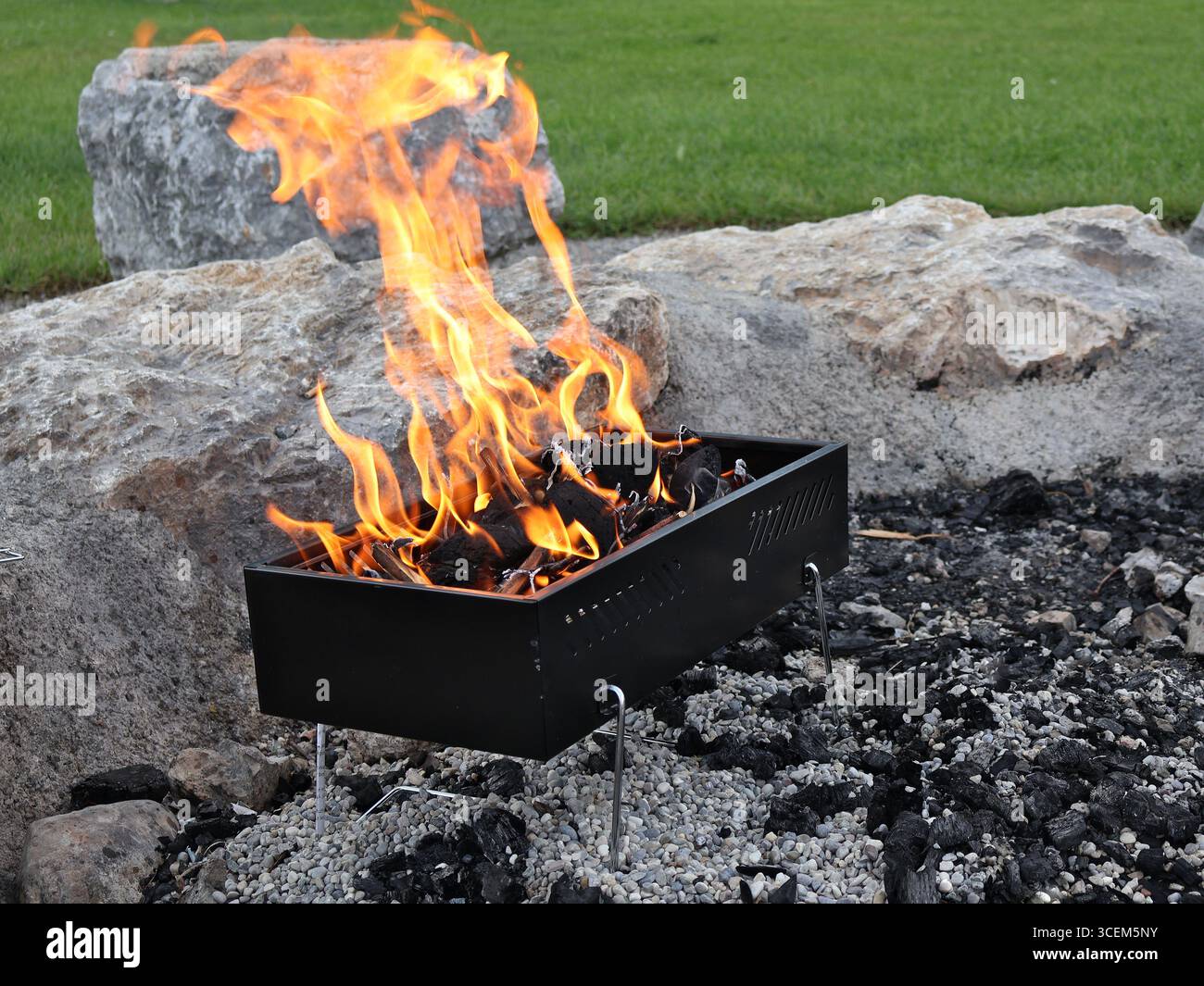Portable Grill with Fire Burning in Outdoor Setting by Stone. A ...