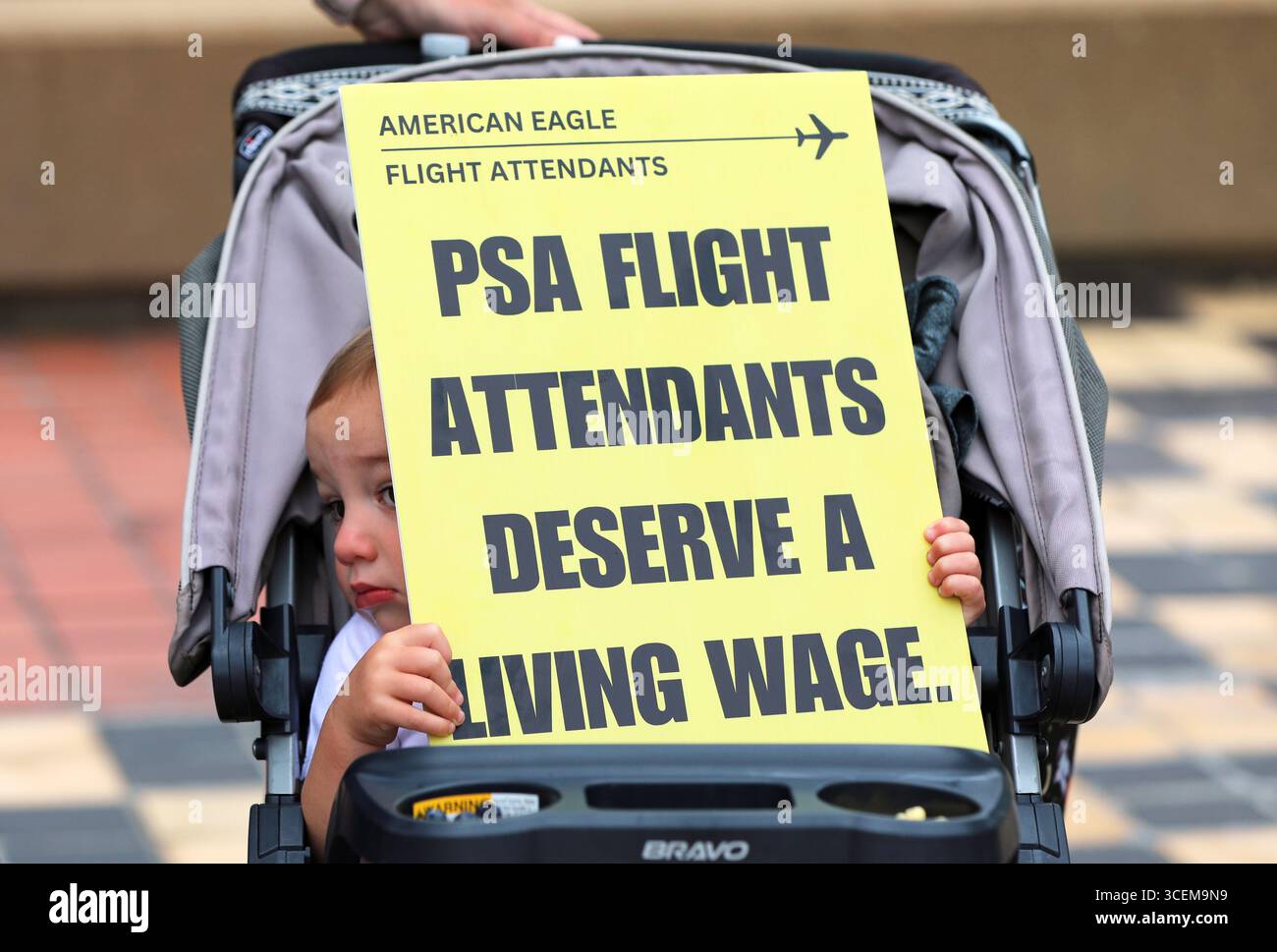 A child is seen with a placard as PSA Airlines flight attendants hold a ...