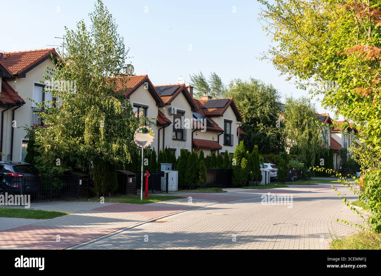 Modern residential neighborhood with red-tiled roof houses and tree ...