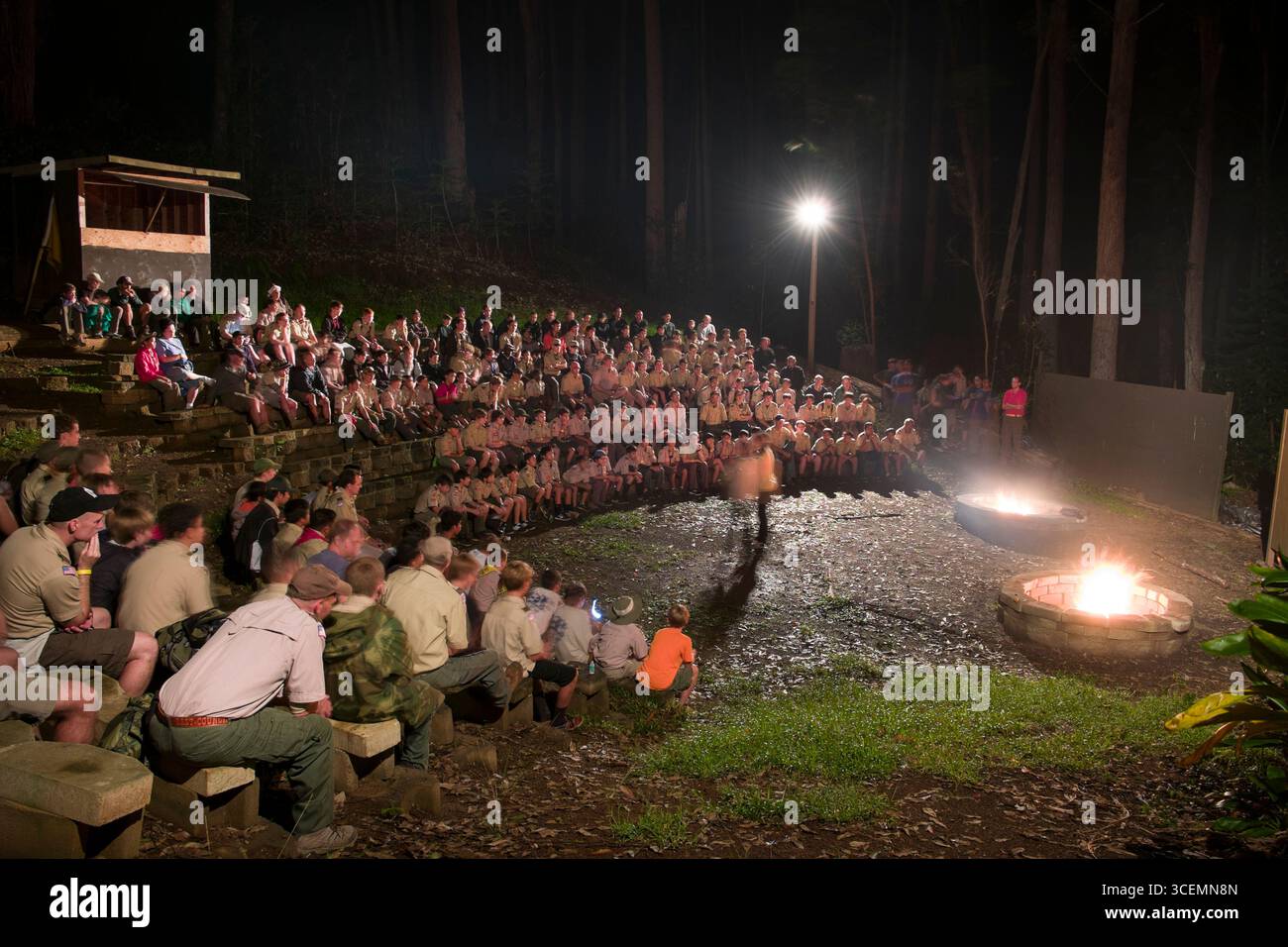 Boy Scouts and adult leaders gathered around campfire during welcoming ...