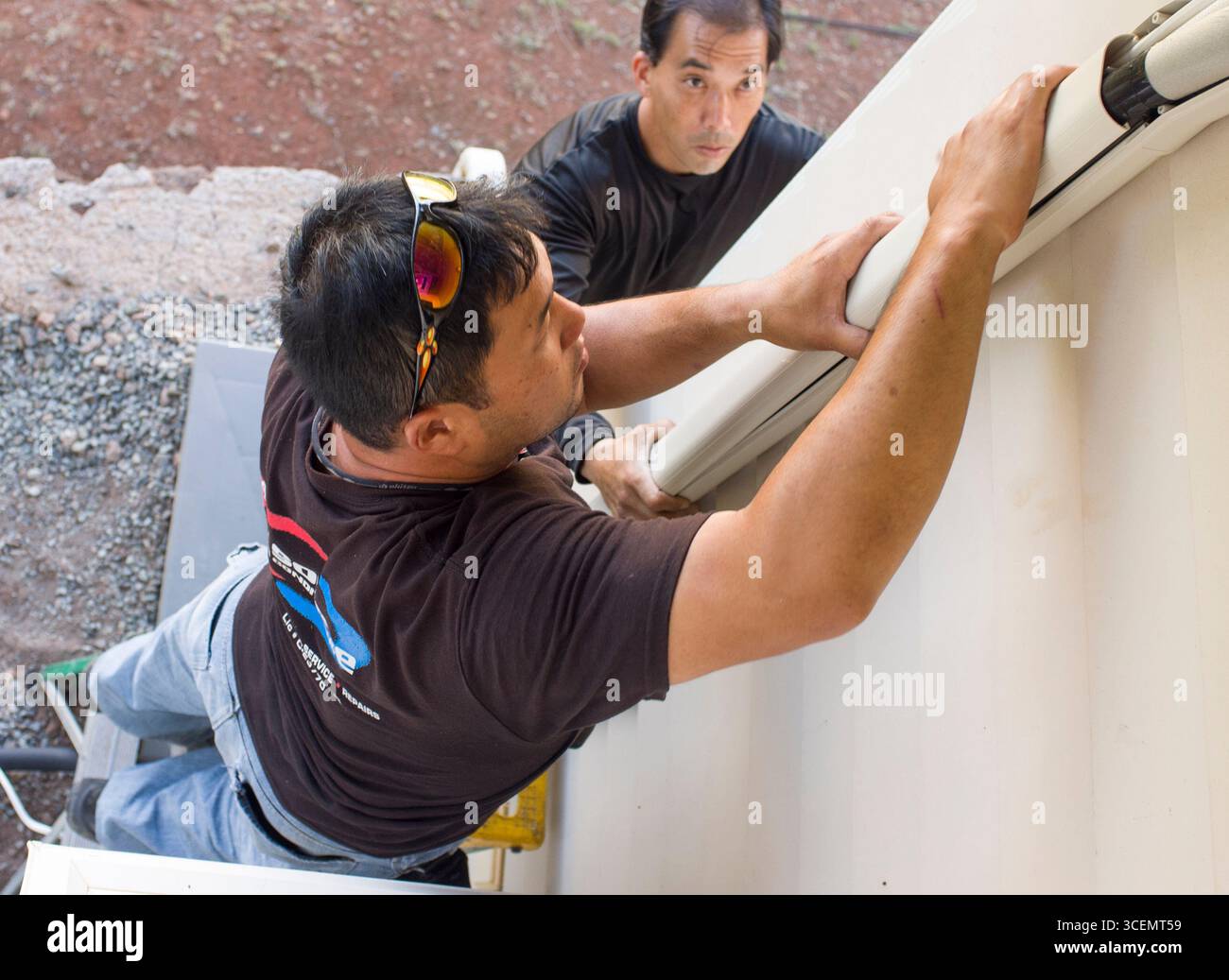 Men putting cover on plastic conduit during installation of Air ...