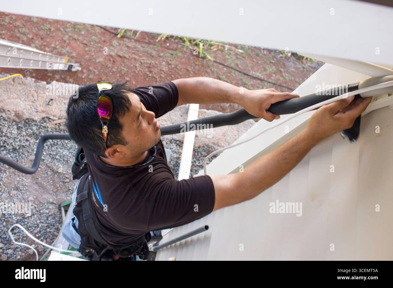 Man covering copper pipe with insulation during installation of Air ...